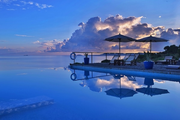 Piscina externa, piscina infinita, guarda-sóis, espreguiçadeiras