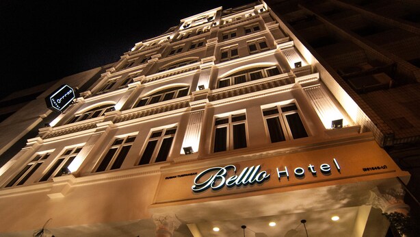 Um hotel com vários andares e uma placa chamativa com a inscrição "Bella Hotel".