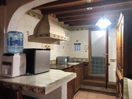 Cozinha com geladeira, bebedouro e pia.