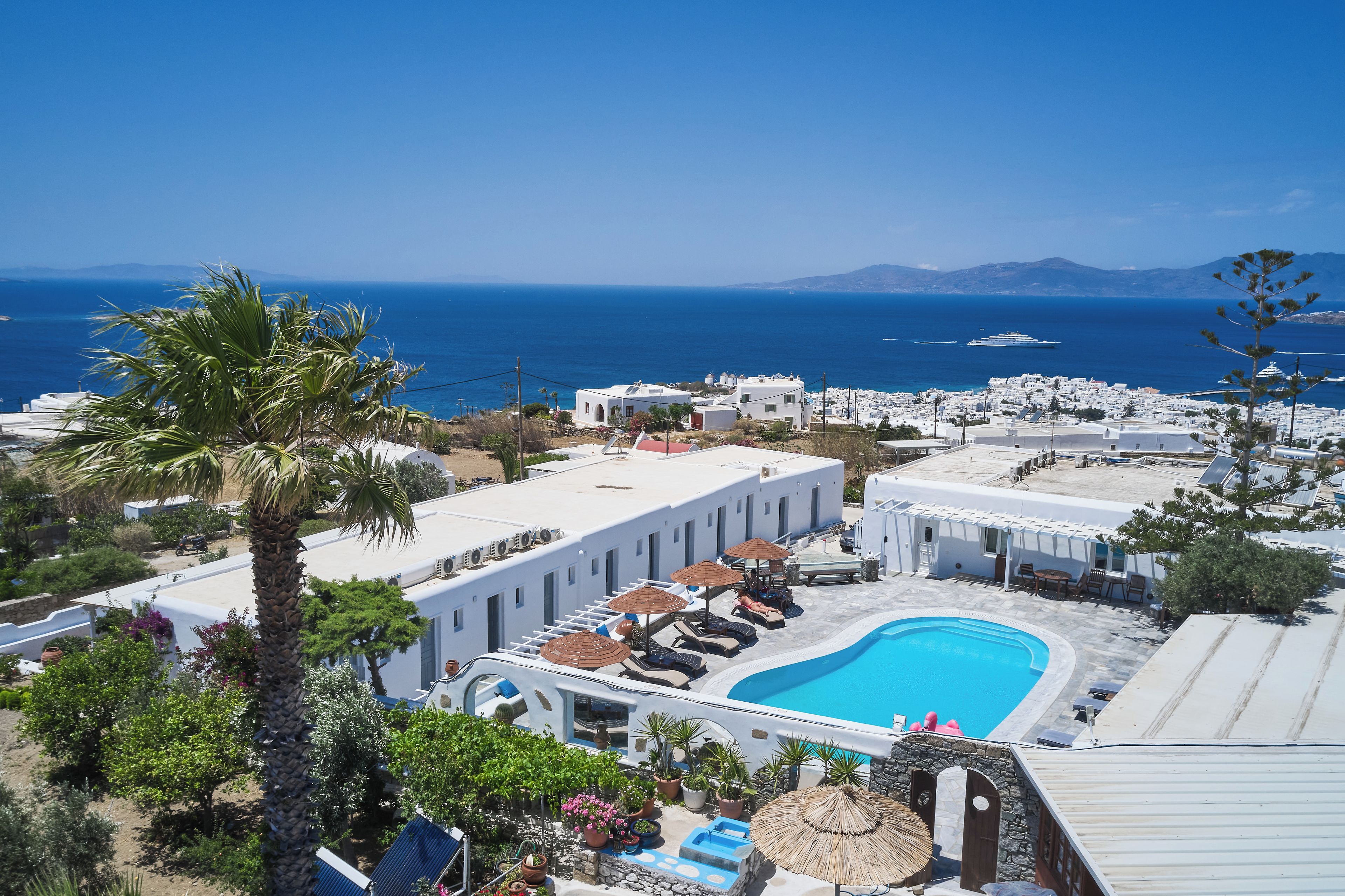 Um resort com piscina, espreguiçadeiras e vista para o mar.