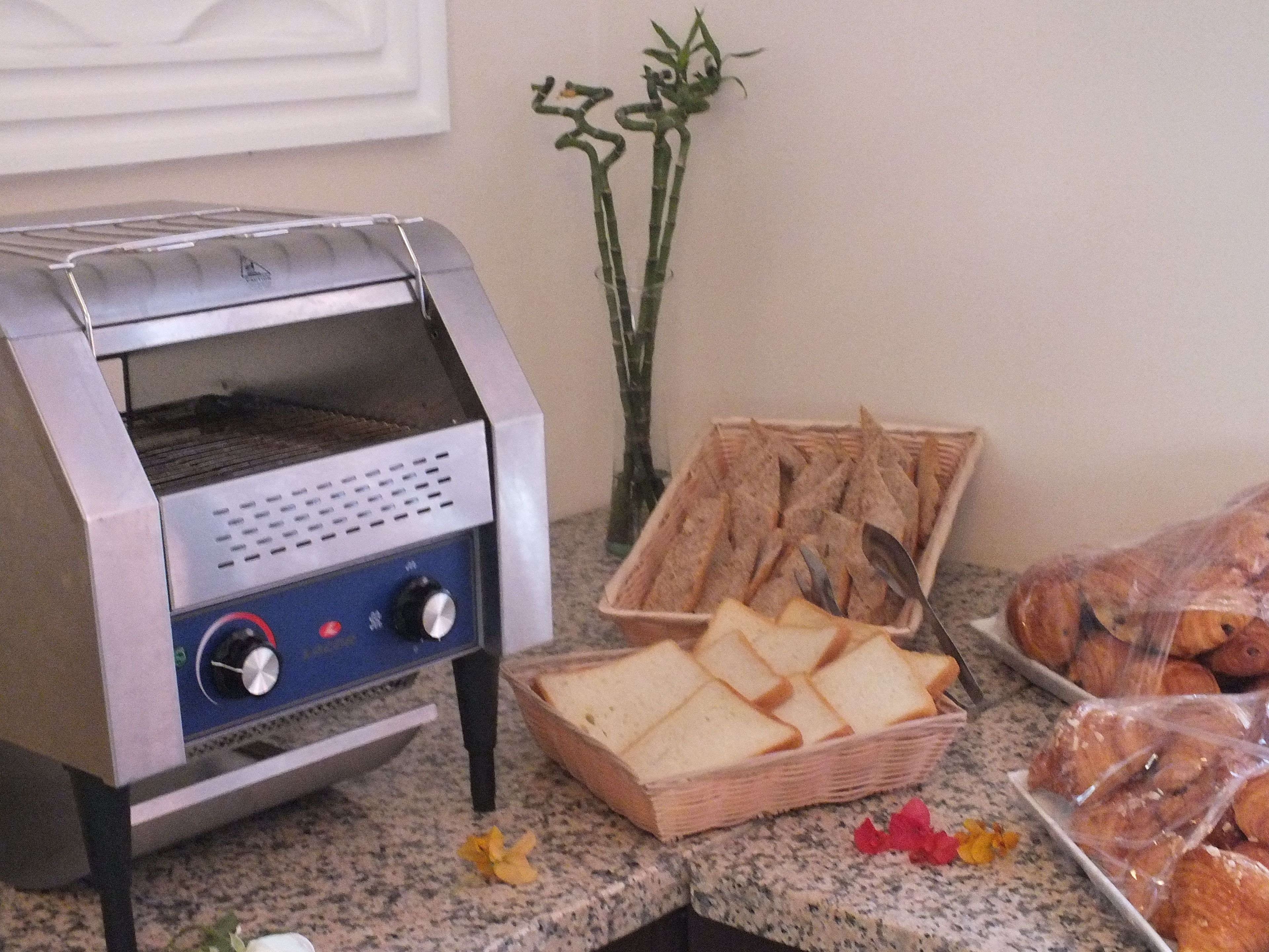 Uma cozinha com forno elétrico, cesta de pão e bandeja de doces.