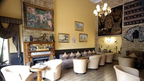 Uma sala de estar acolhedora com lareira, assentos confortáveis e diversas decorações nas paredes.
