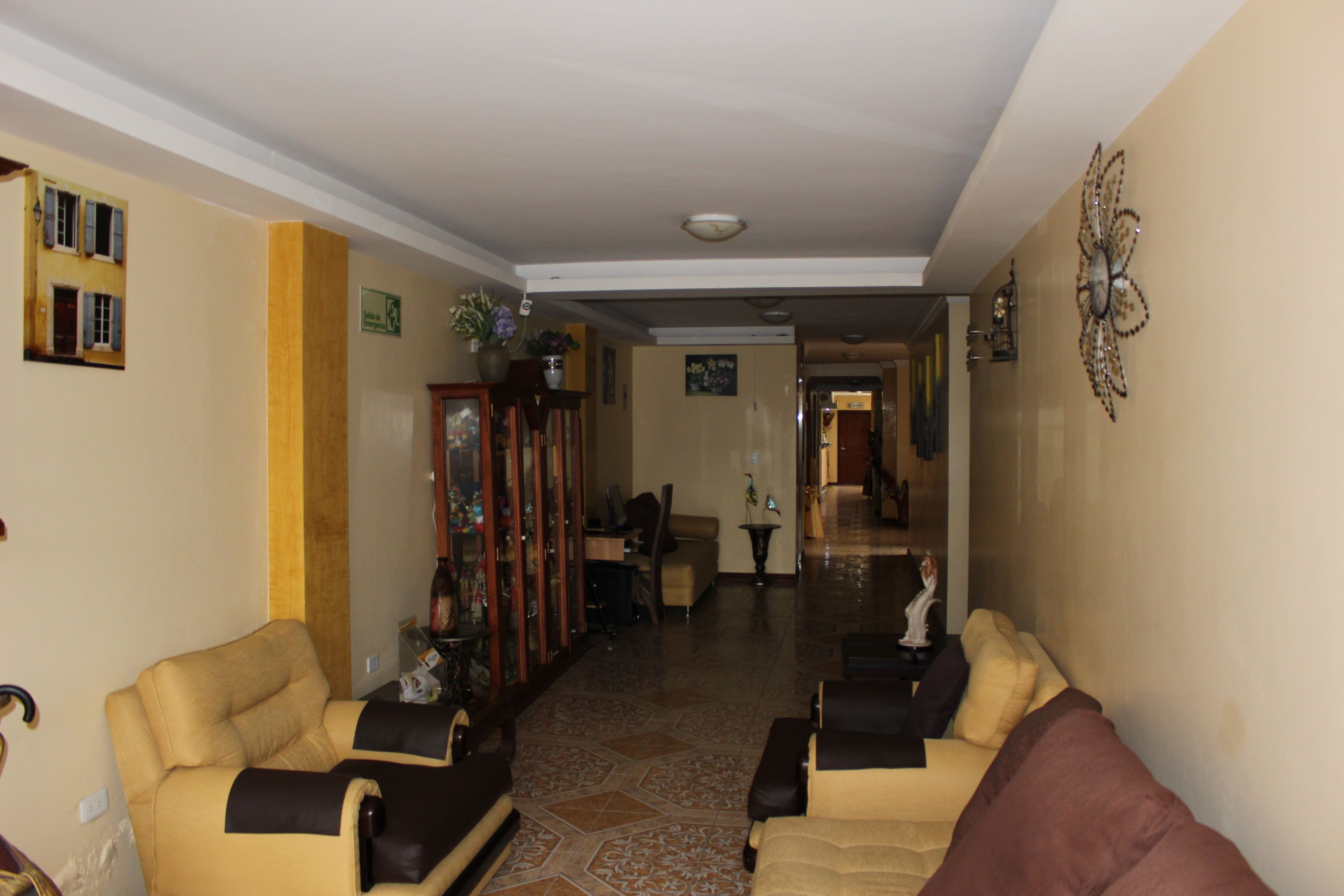 Uma sala de estar com dois sofás, um armário e um objeto decorativo na parede.