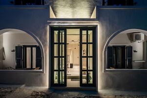 Entrada de um edifício moderno com portas de vidro e janelas em arco.