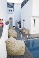 Área na piscina com espaço de estar e escadaria para um nível superior.
