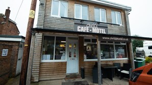Um edifício de dois andares com uma placa que diz "Chris's Cafe-Motel".