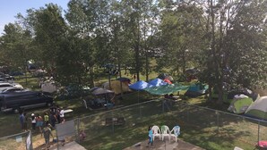 Uma área de camping com tendas, piscina e cadeiras de gramado.