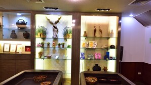 Uma área de spa com duas banheiras de imersão, prateleiras com objetos decorativos e um balcão de recepção.