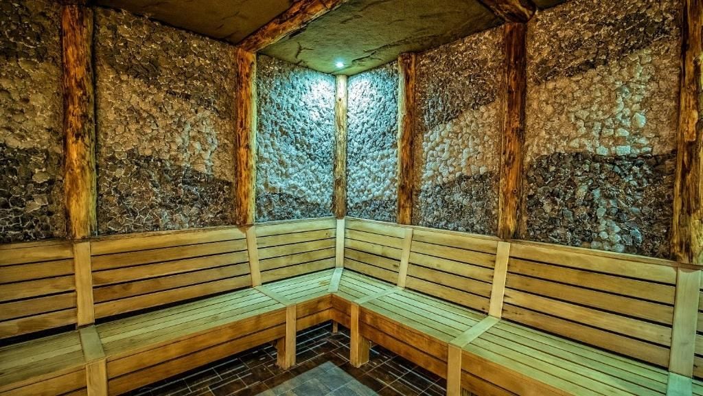 Uma sauna com bancos de madeira e paredes de pedra.
