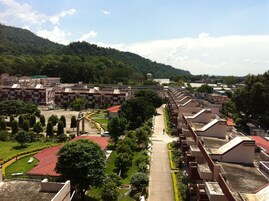 Área residencial com edifícios de apartamentos, um caminho central e vegetação ao redor.