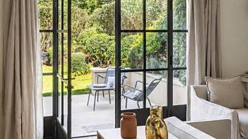 Quarto com uma grande porta de vidro deslizante que dá para uma área externa com mesa e cadeiras.