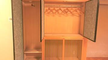 Um closet espaçoso com portas abertas, que inclui um cabideiro e um módulo de armazenamento com prateleiras.