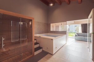 Uma casa de banho moderna com cabine de duche em vidro, banheira de hidromassagem integrada e vista para o exterior.