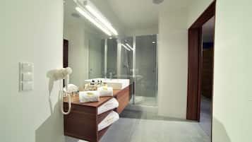 Casa de banho moderna com toucador, secador de cabelo e cabine de duche em vidro.