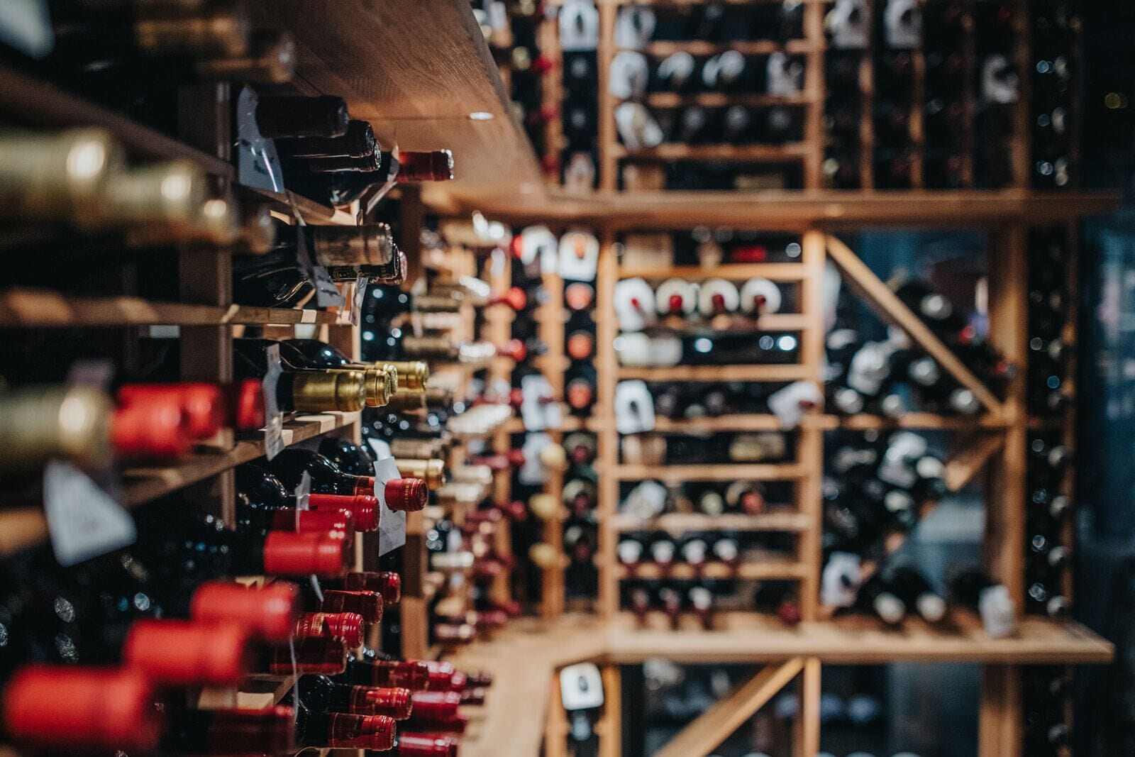 Uma adega com inúmeras garrafas de vinho em estantes de madeira.