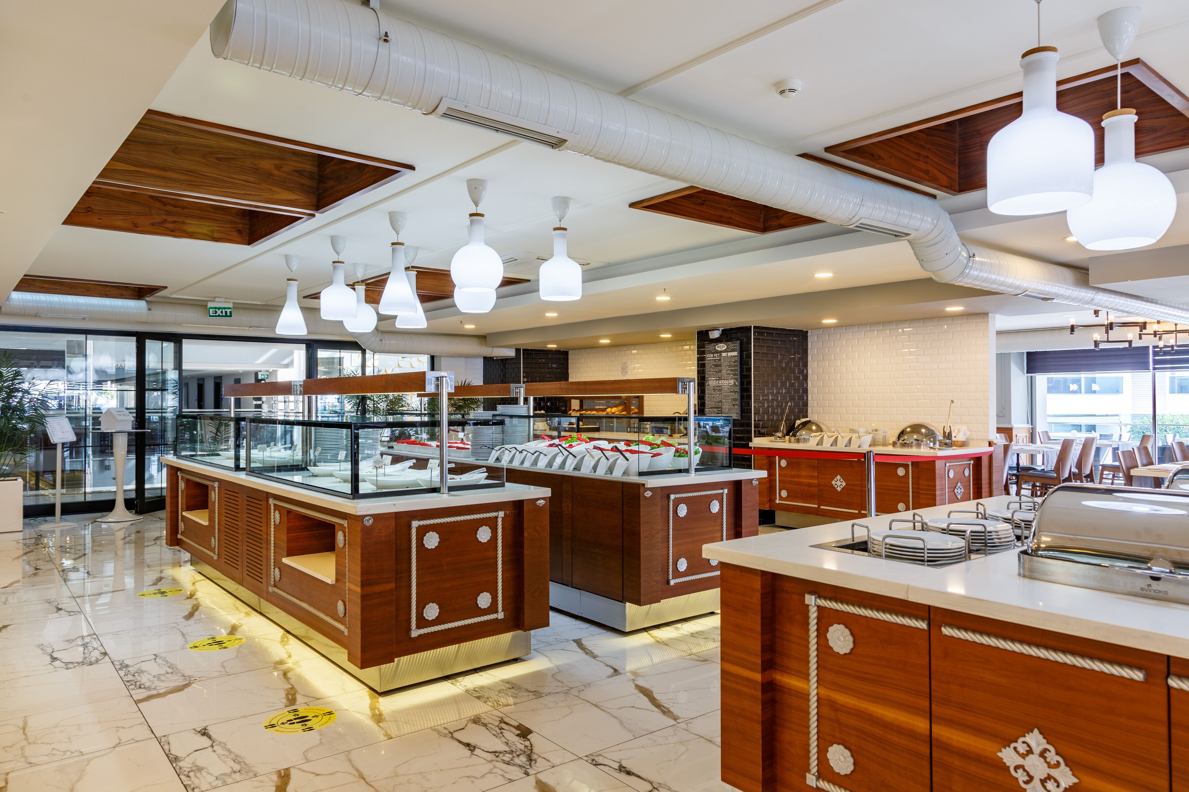 Um restaurante moderno com detalhes em madeira, vitrines de vidro e um sistema de buffet.