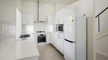 Apartamento executivo, 2 quartos | Cozinha privada | Geladeira grande, micro-ondas, fogão, cooktop