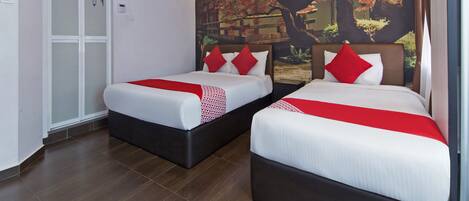 Quarto de hotel com duas camas, uma janela grande e um mural de folhas de outono.