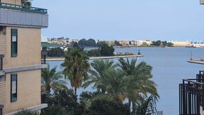 Vista costeira com um edifício com varandas e vista para o mar.