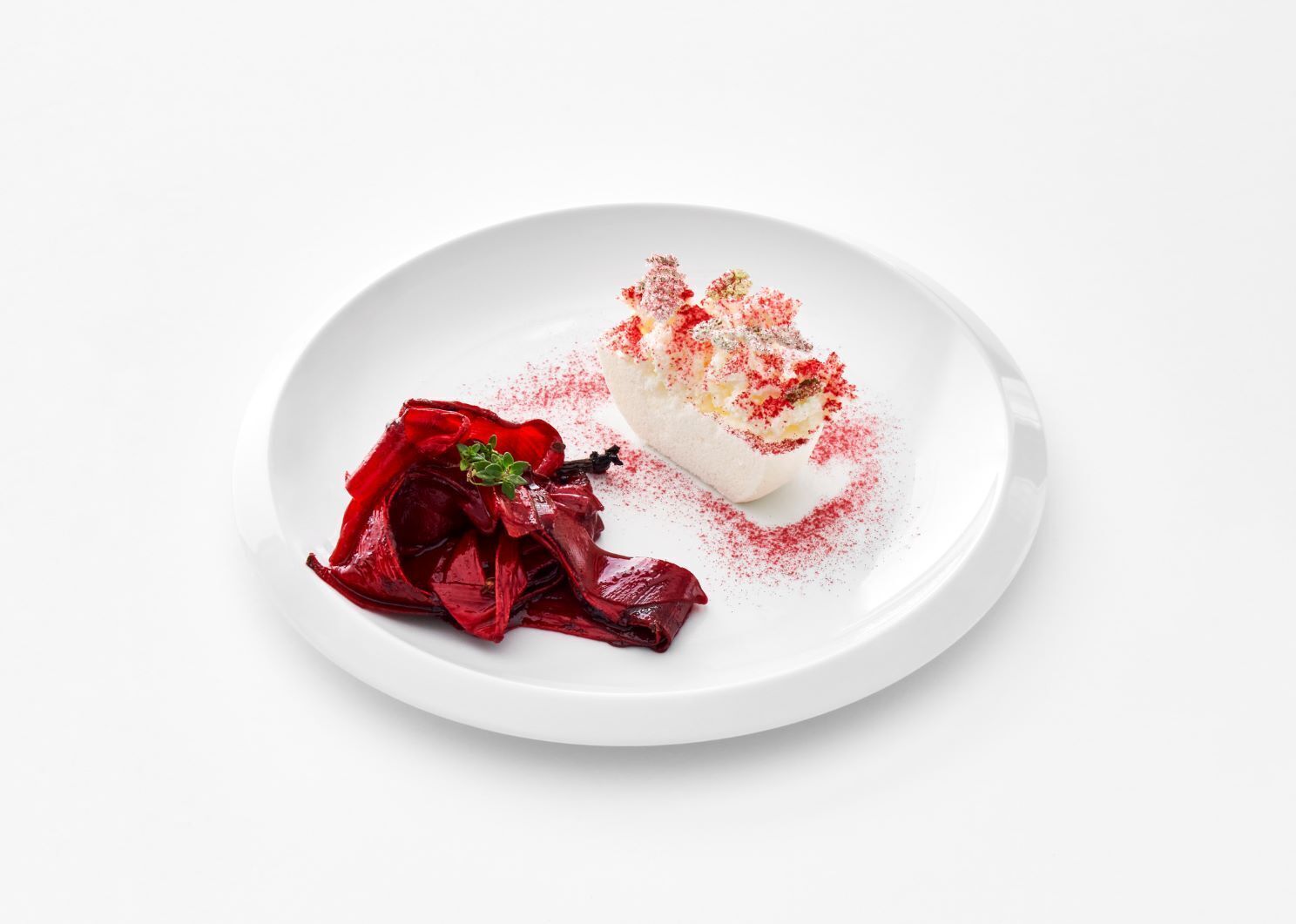 Um prato branco com uma sobremesa e um enfeite vermelho.