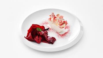 Um prato branco com uma sobremesa e um enfeite vermelho.