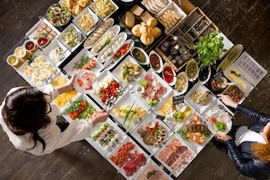 Vista de cima de um buffet com diversos alimentos e acompanhamentos.