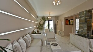 Uma sala de estar moderna com sofá, mesa de centro e luminária suspensa.