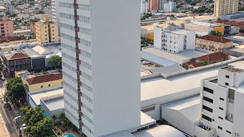 Um hotel moderno e imponente, com design contemporâneo, destacando uma estrutura vertical marcante e uma entrada curva.