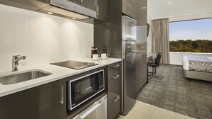 Uma cozinha moderna com eletrodomésticos de aço inoxidável, micro-ondas embutido e uma pia.