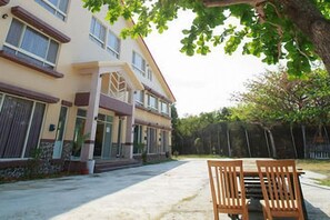 Um edifício de dois andares com área de estar coberta ao ar livre.
