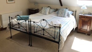 Quarto com cama, mesa de cabeceira, abajur e janela.