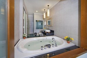 Uma casa de banho moderna com uma banheira grande, uma pia e um espelho.