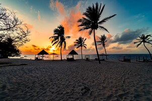 Praia particular, espreguiçadeiras, guarda-sóis, toalhas de praia 
