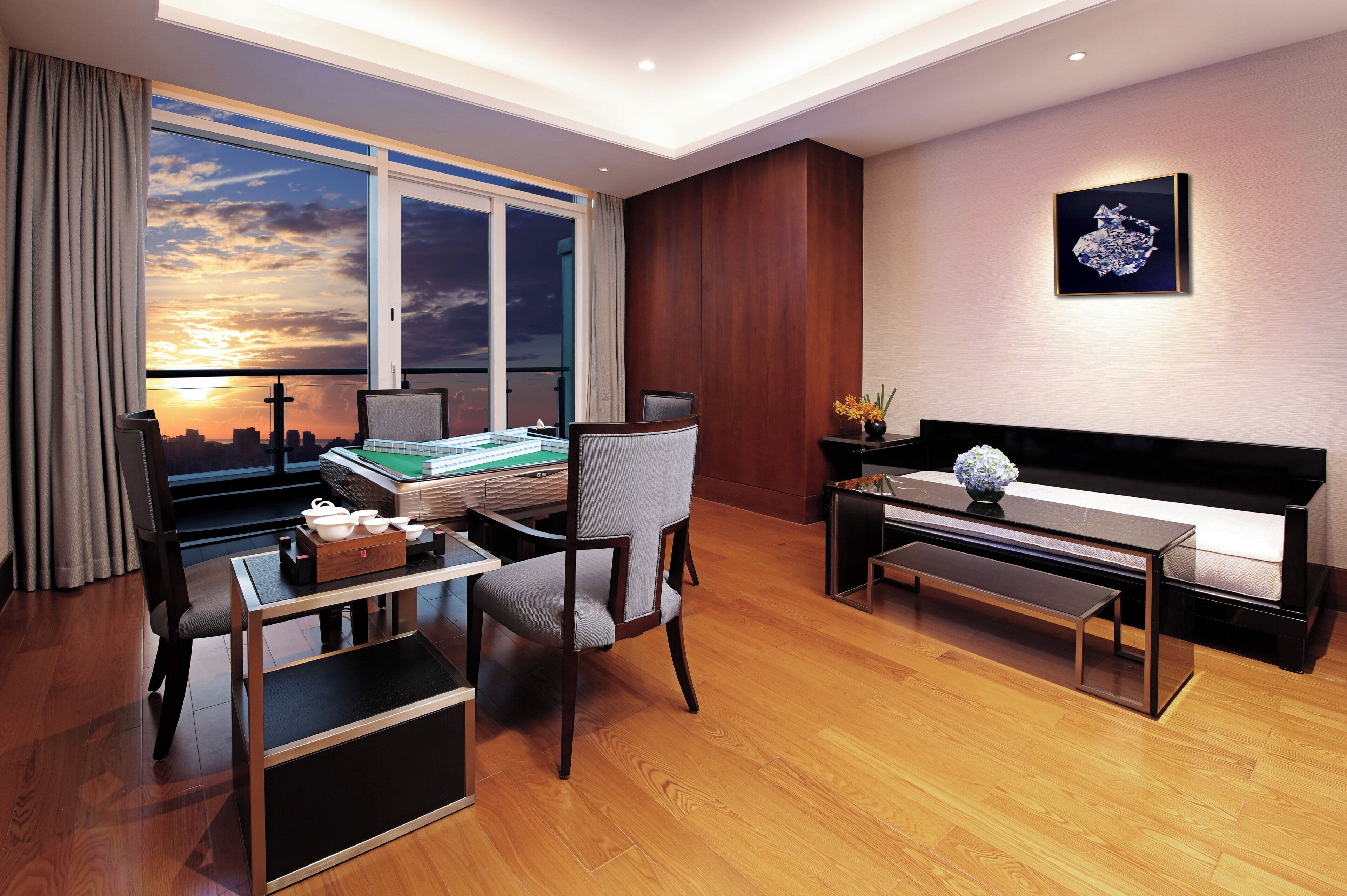 Uma sala de estar moderna com vista para o pôr do sol, um sofá, uma mesa de jantar e uma mesa de centro.