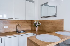 Apartamento, 1 quarto, sacada | Cozinha privada | Geladeira grande, lava-louças, talheres/pratos/utensílios de cozinha