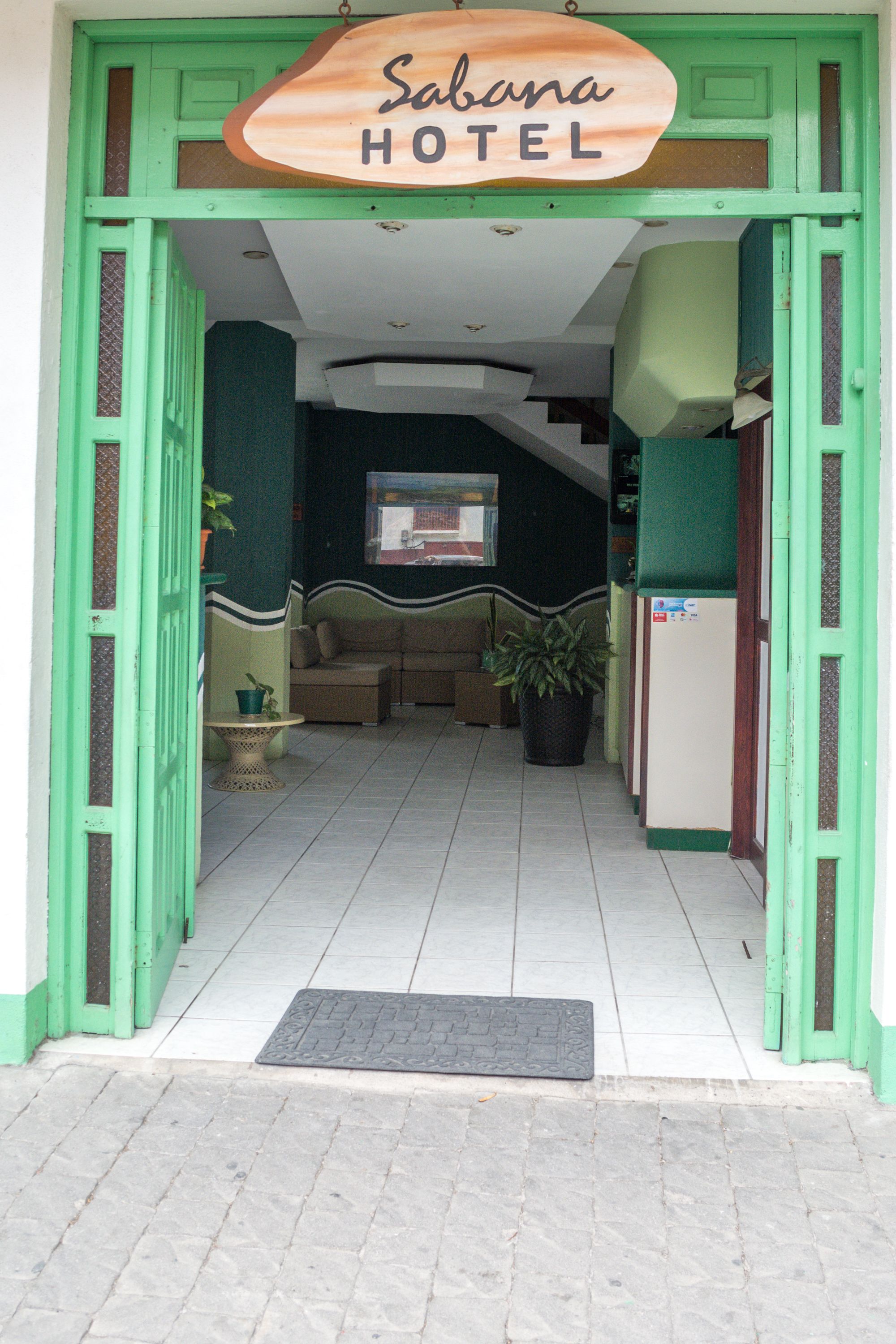 A entrada de um hotel com uma placa indicando "Sabana HOTEL".