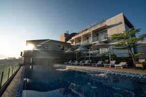 Hotel com piscina, área de solário e design arquitetônico moderno.