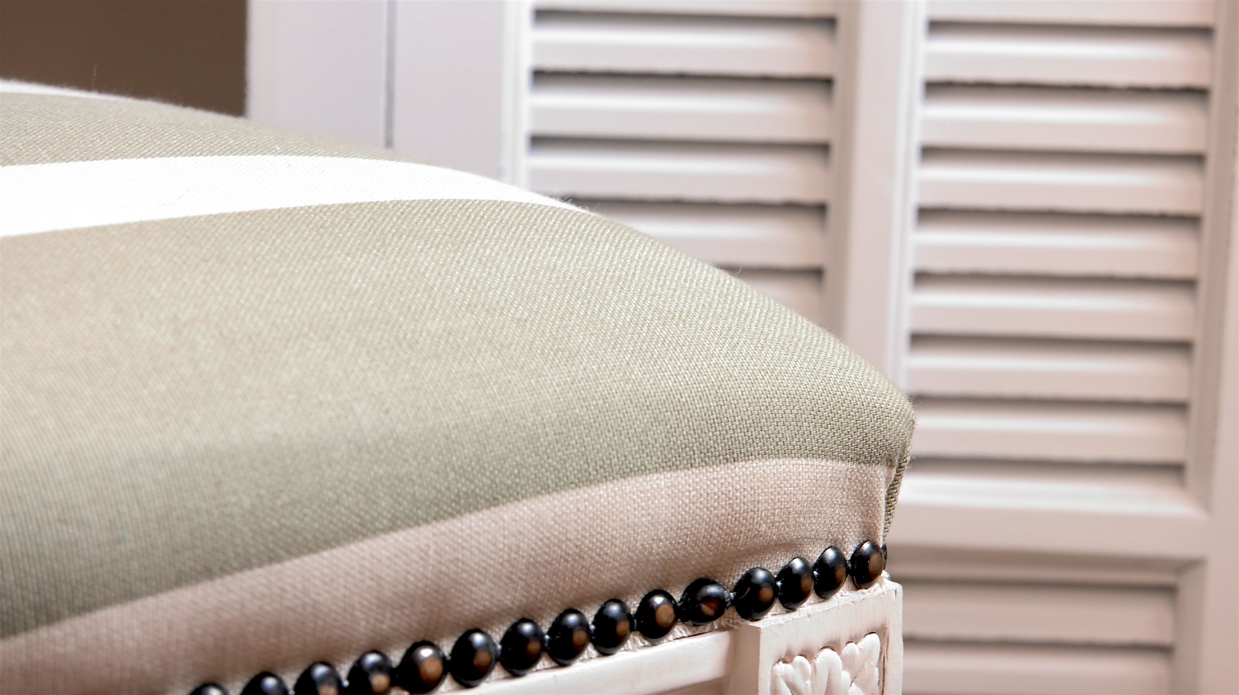 Um close-up de um travesseiro com tecido texturizado e acabamento de contas decorativas.