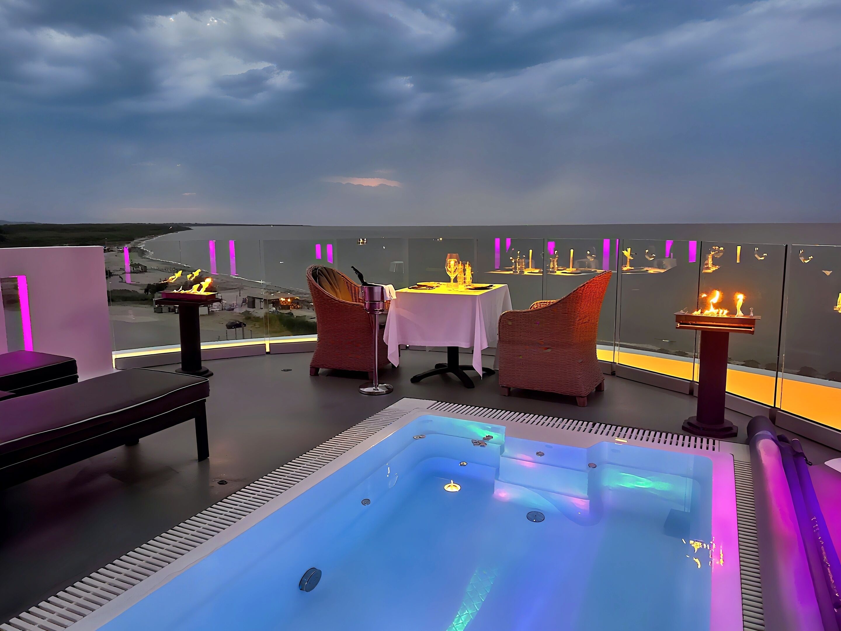 Terraço no telhado com banheira de hidromassagem, área de estar e mesa posta para refeições.