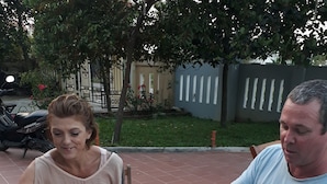 Uma mesa redonda de metal com diversos pratos, incluindo mariscos e arroz, posta ao ar livre.