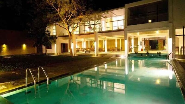 Um edifício moderno com piscina à noite.