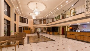 Um hall amplo com balcão de recepção, área de estar e um lustre.