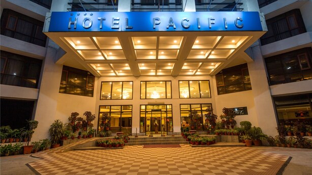 Entrada de hotel com uma placa azul que diz "HOTEL PACIFIC".