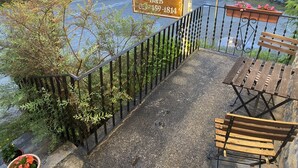 Uma placa de madeira com nome e endereço, um banco, um corrimão e uma placa de rua.