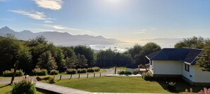 Uma cabana com vista para montanhas e um lago.