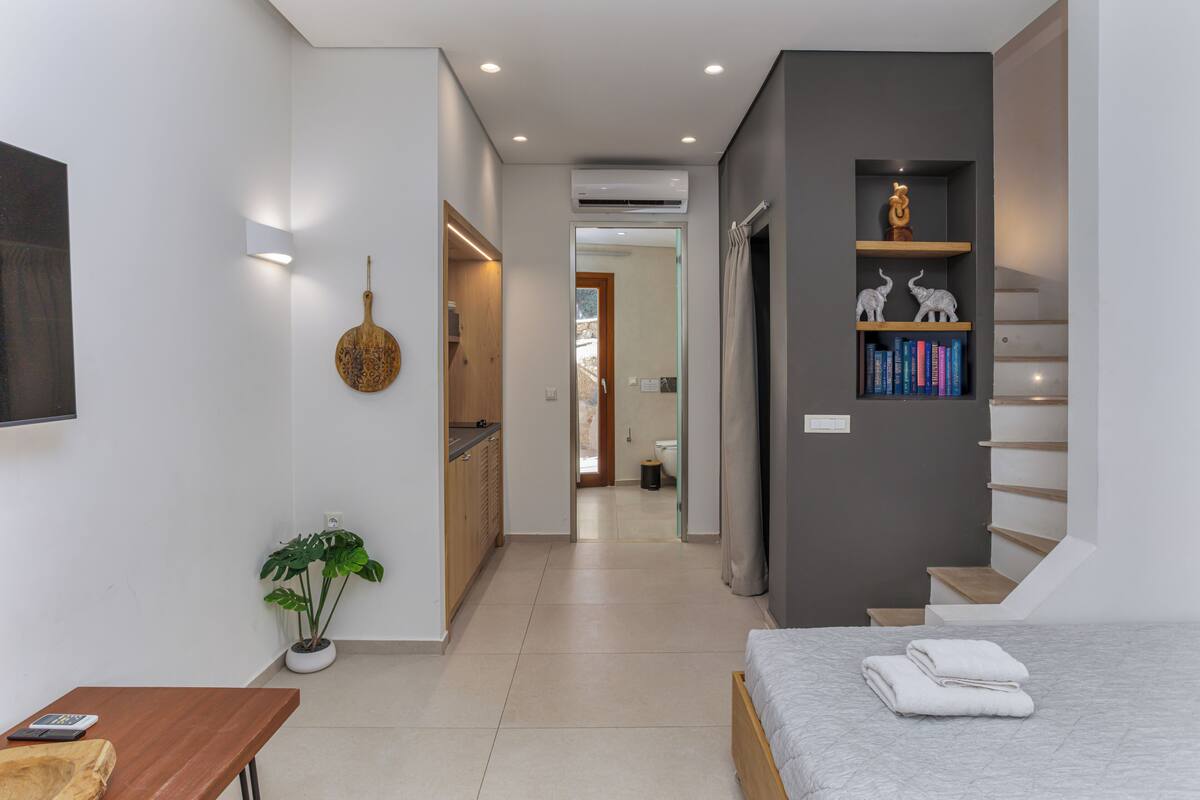 Quarto moderno com cama, mesa de cabeceira e um vaso com planta.