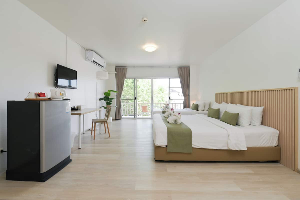 Quarto de hotel moderno com cama, escrivaninha e televisão.
