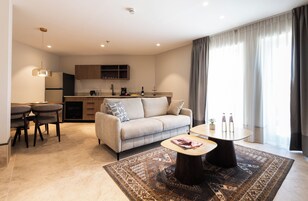 Uma sala de estar moderna com sofá, mesa de centro e área de refeições.