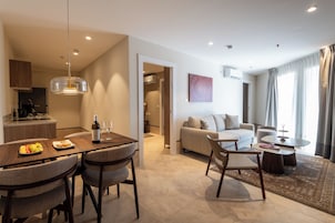 Uma sala de estar moderna com sofá, mesa de centro e área de jantar com cadeiras e uma mesa.