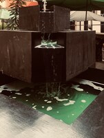 Um espelho d'água com uma fonte central e uma piscina ao redor.